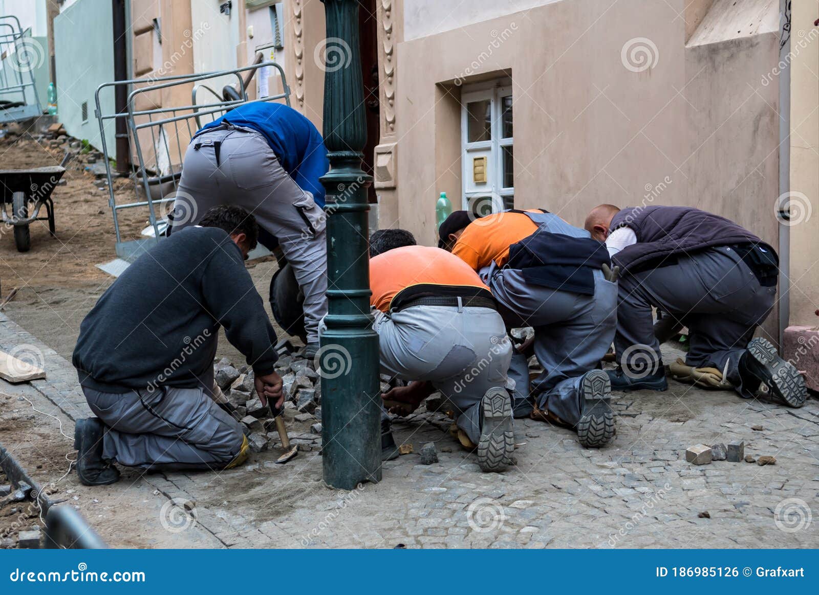 Team of Construction Workers Building Pavement with Cobblestones ...