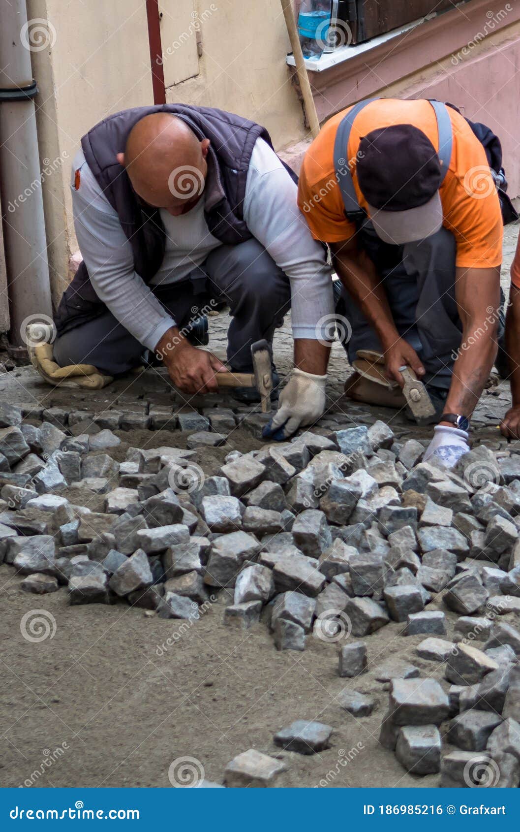 Team of Construction Workers Building Pavement with Cobblestones ...