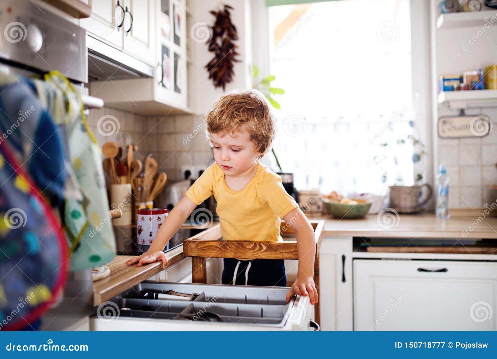 A Small Toddler Boy Standing in a Kitchen at Home. Stock Image - Image ...