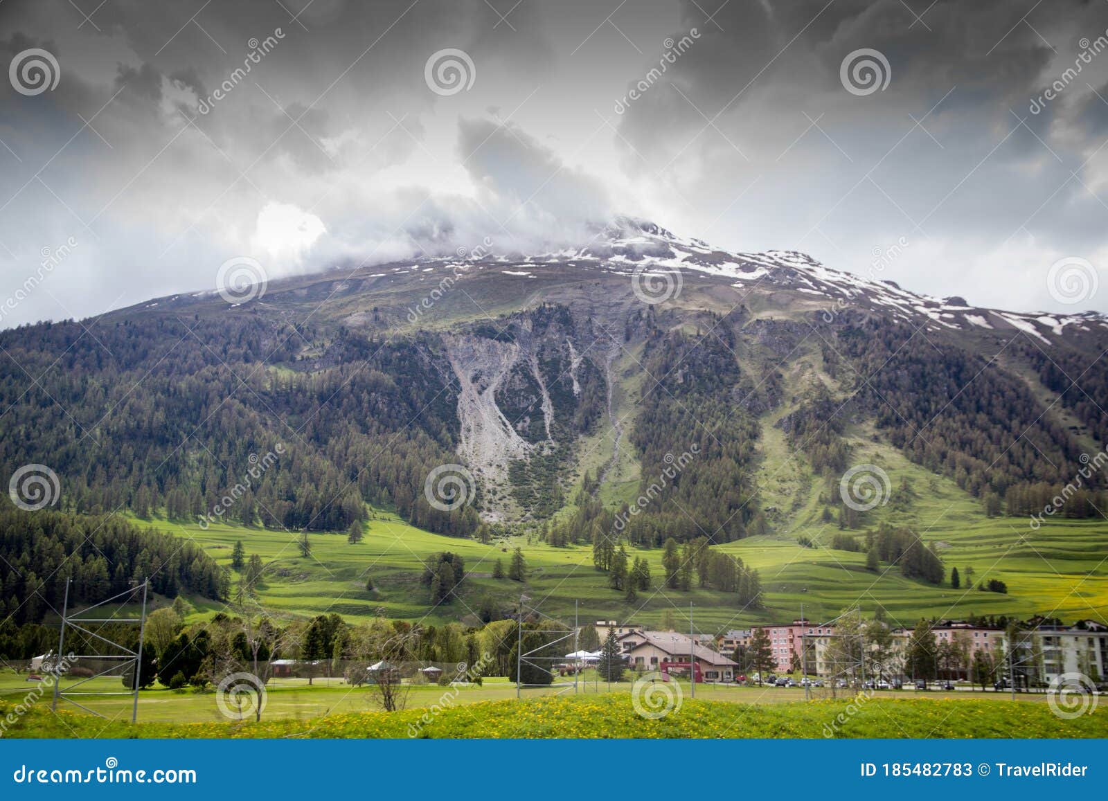 Small Town in Alps Valley. Dramatic Looking Sky with Eye Catching Green ...