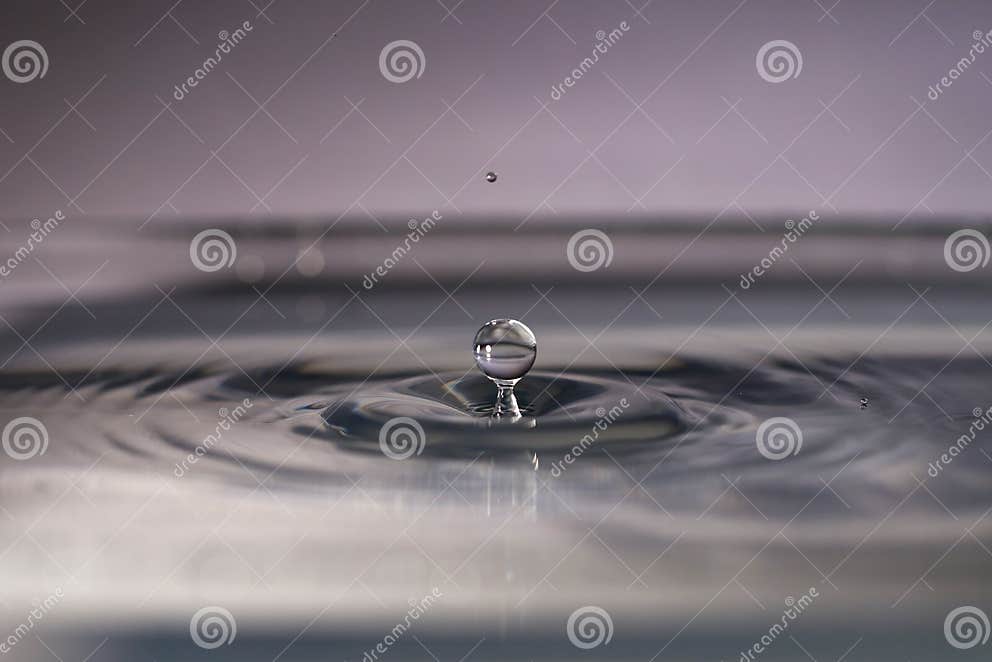 Small Water Drop Fall on Water Surface Creating a Splash and Ripples ...