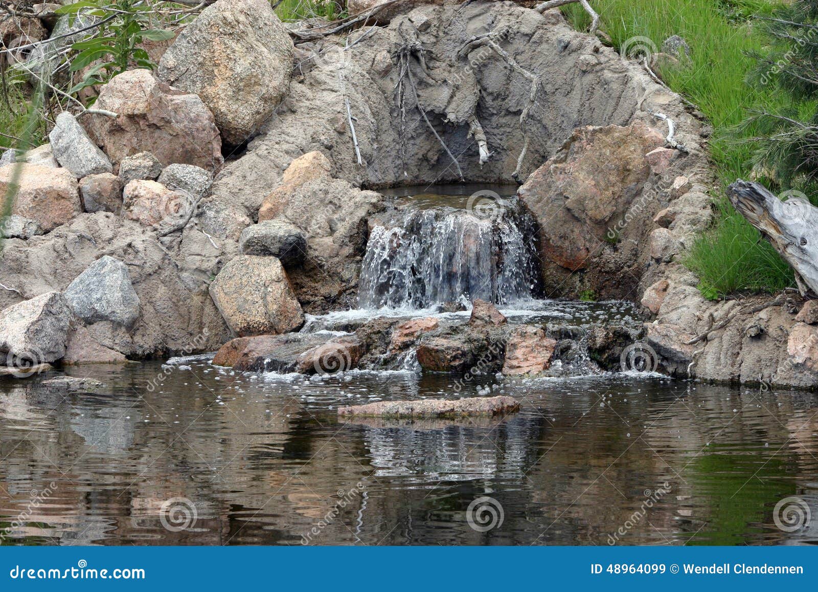 Small Waterfall Flowing from Rocky Outcropping into Pond Stock Image ...