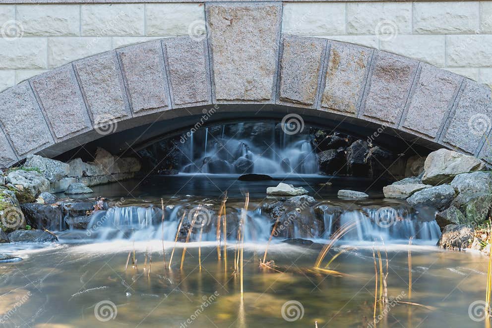 A Small Waterfall Under a Bridge Stock Photo - Image of stream, river ...