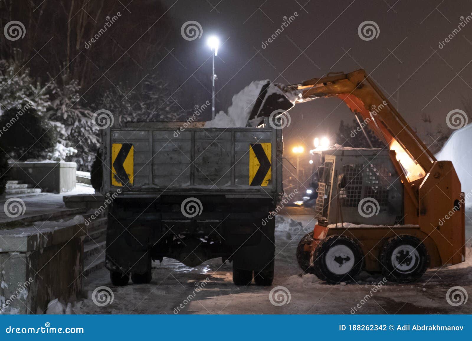 Small Wheel Loader is Unloading Snow into a Dump Truck. Stock Photo ...