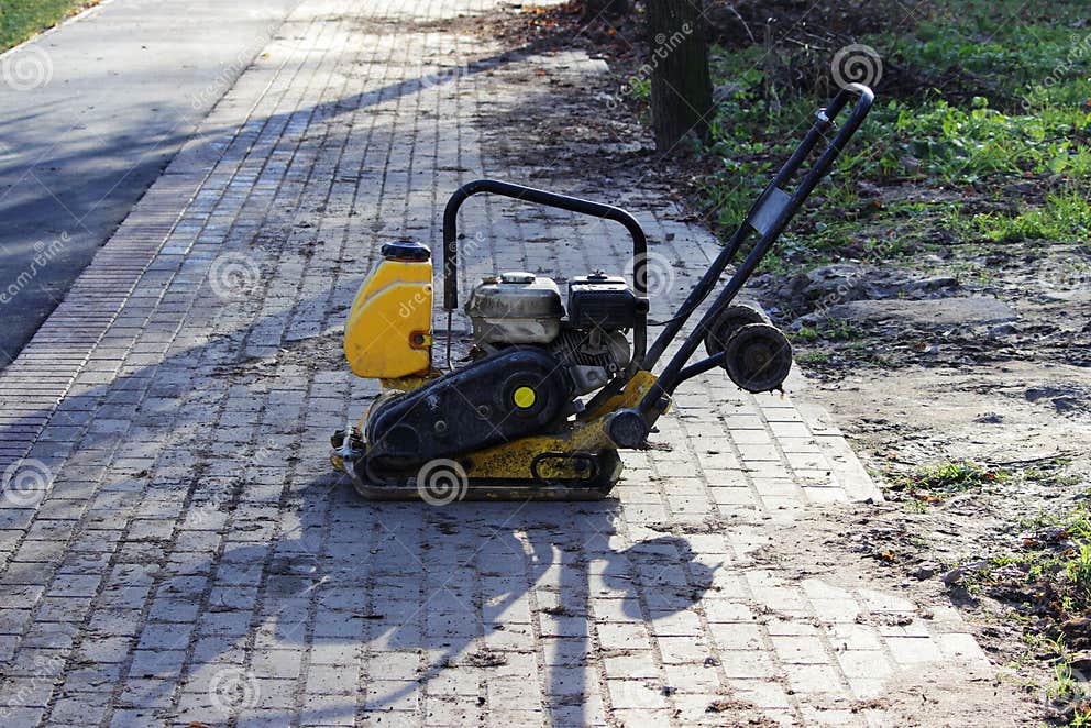 Small Yellow Compactor Standing on New Gray Pavement Stock Image ...