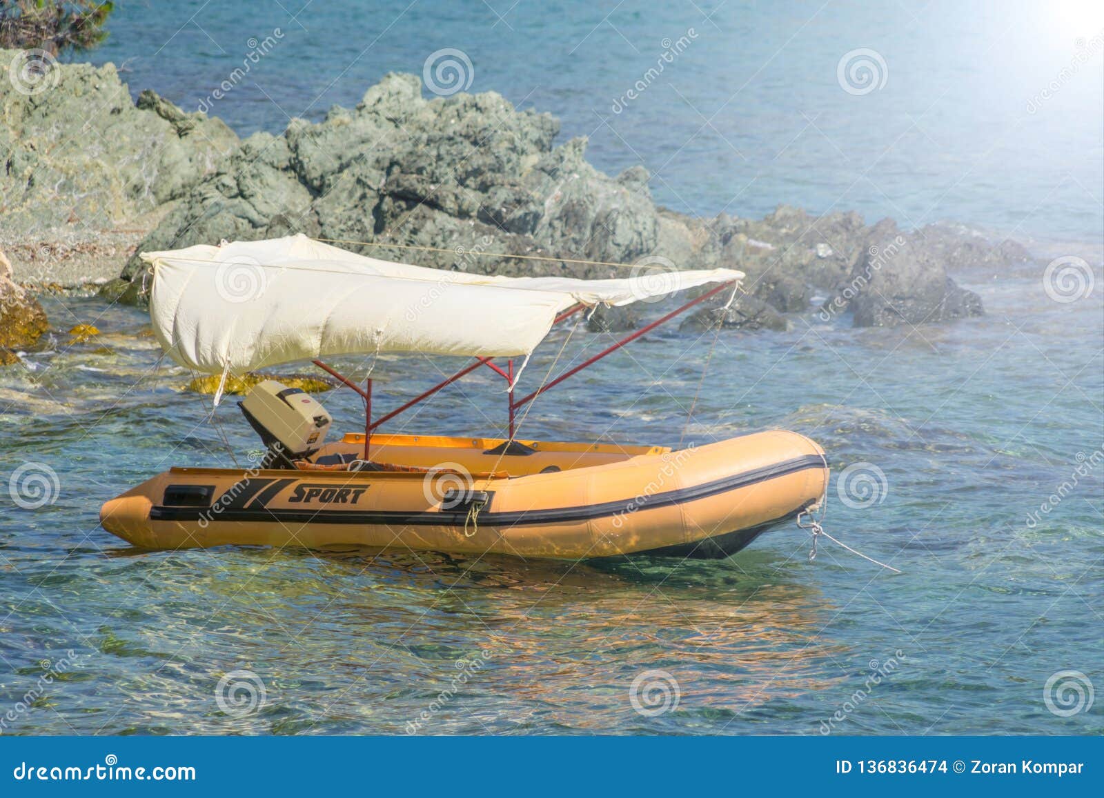 Small Yellow Motorized Boat Anchored on the Shore in Front of Rocks ...
