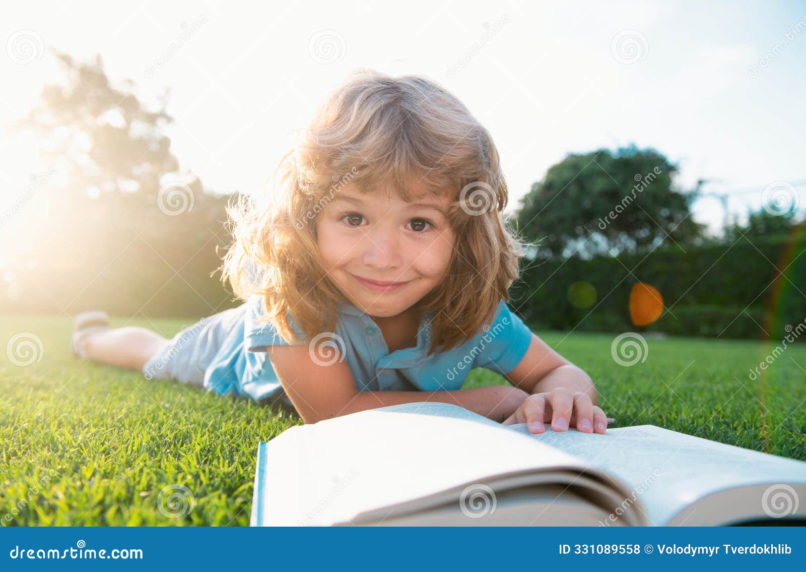 Smart Clever Boy Reading Book on Green Grass. Stock Photo - Image of ...