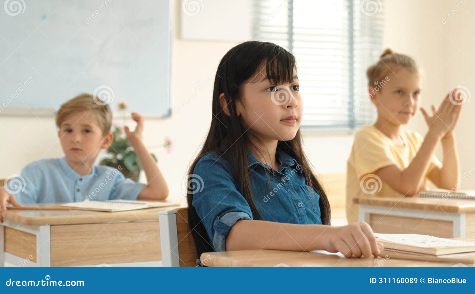 Smart Elementary Student Looking at Teacher while Attend in Classroom ...