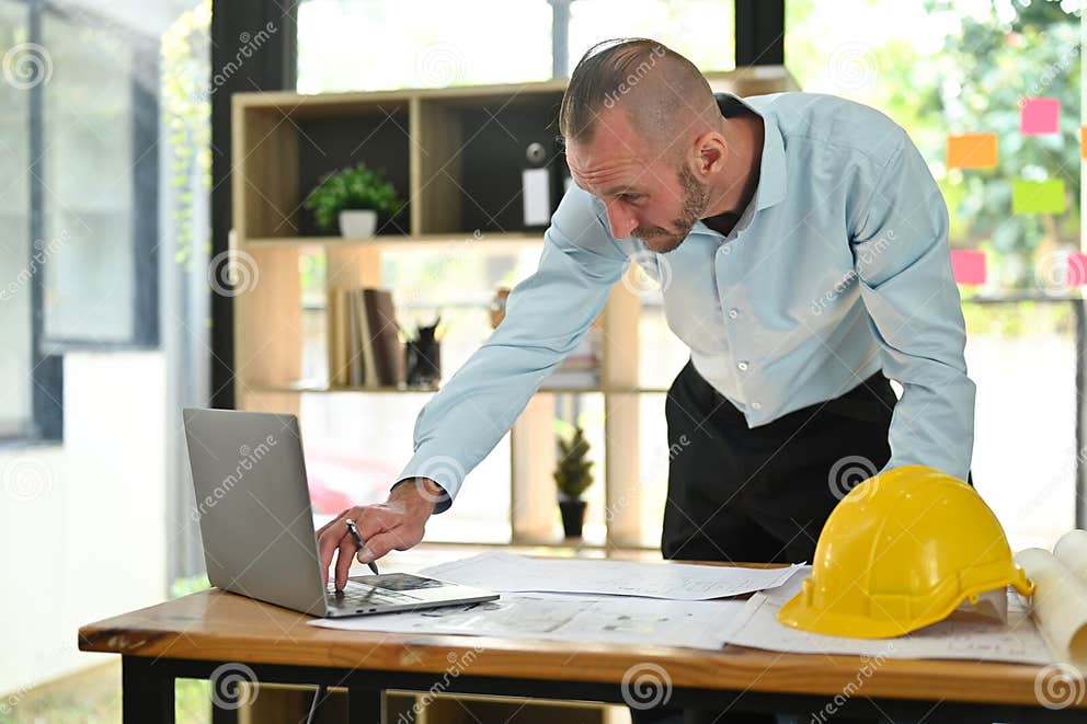 Smart Engineer Man in Shirt Using Laptop and Working with Blueprints, Planning Development ...