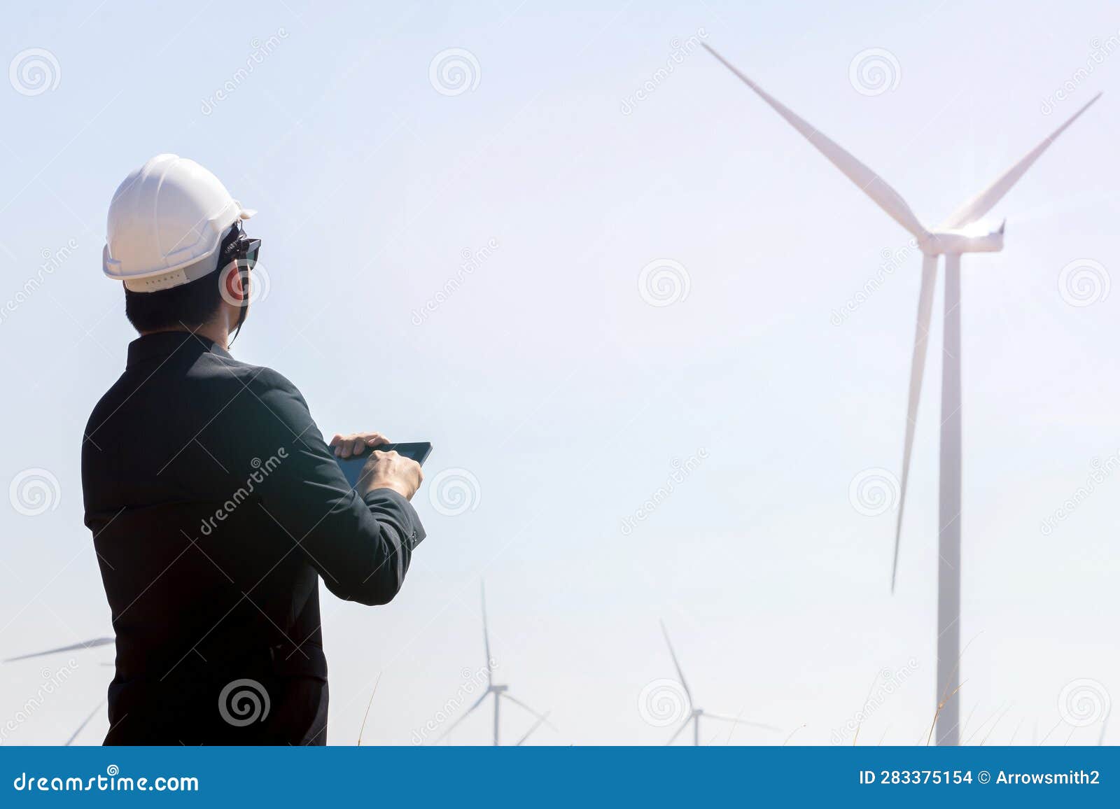 Smart Engineer Man Stands Using Tablet Front the Wind Turbines ...