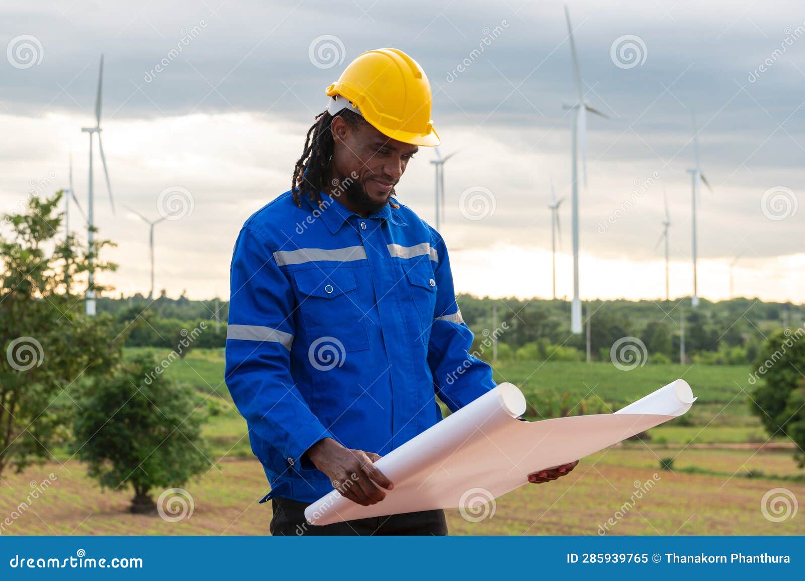Smart Engineer with Protective Helmet Holding the Blueprint Working at ...