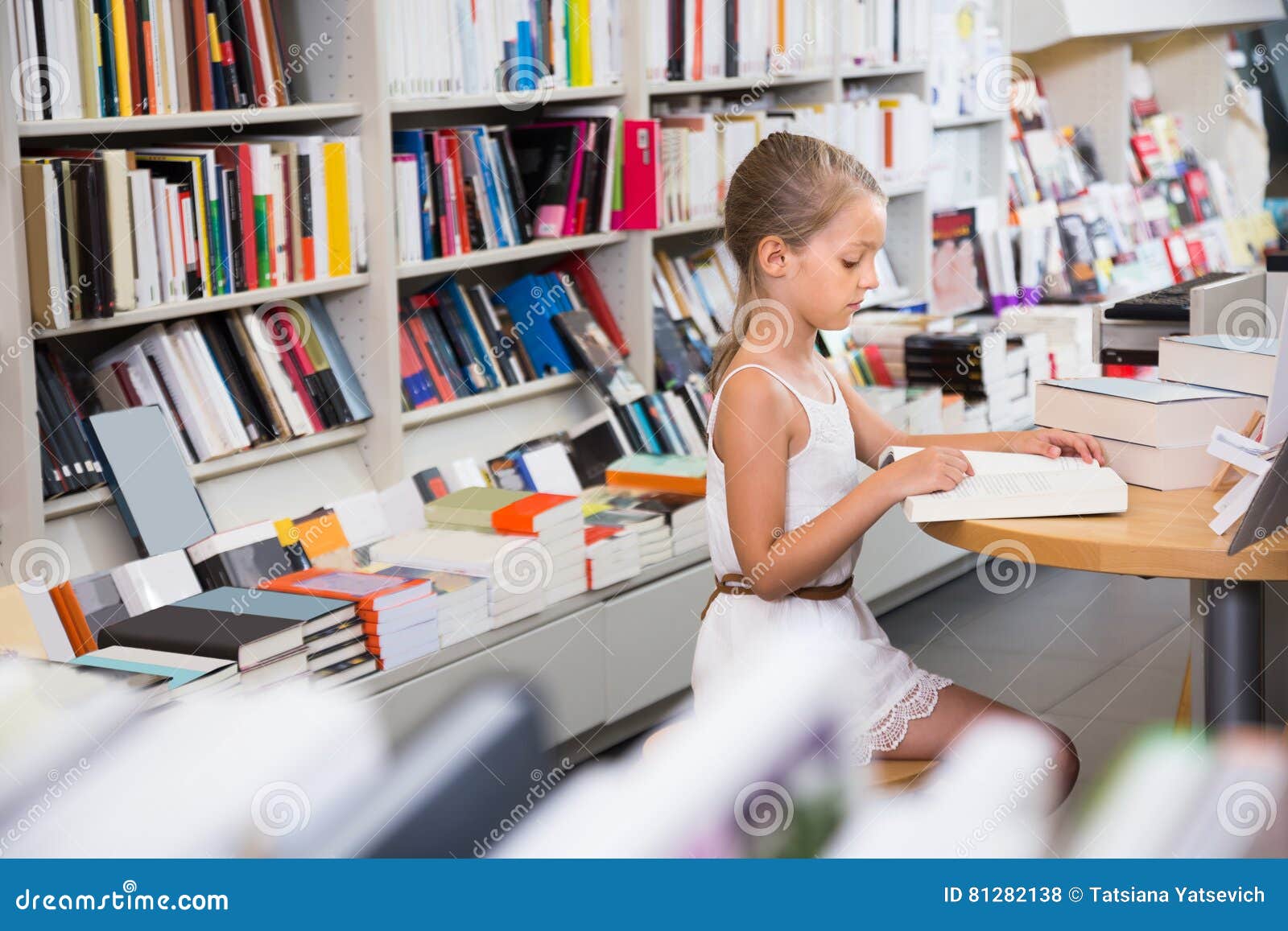 Smart Girl Child is Engaged with a Book in the Library Stock Photo ...