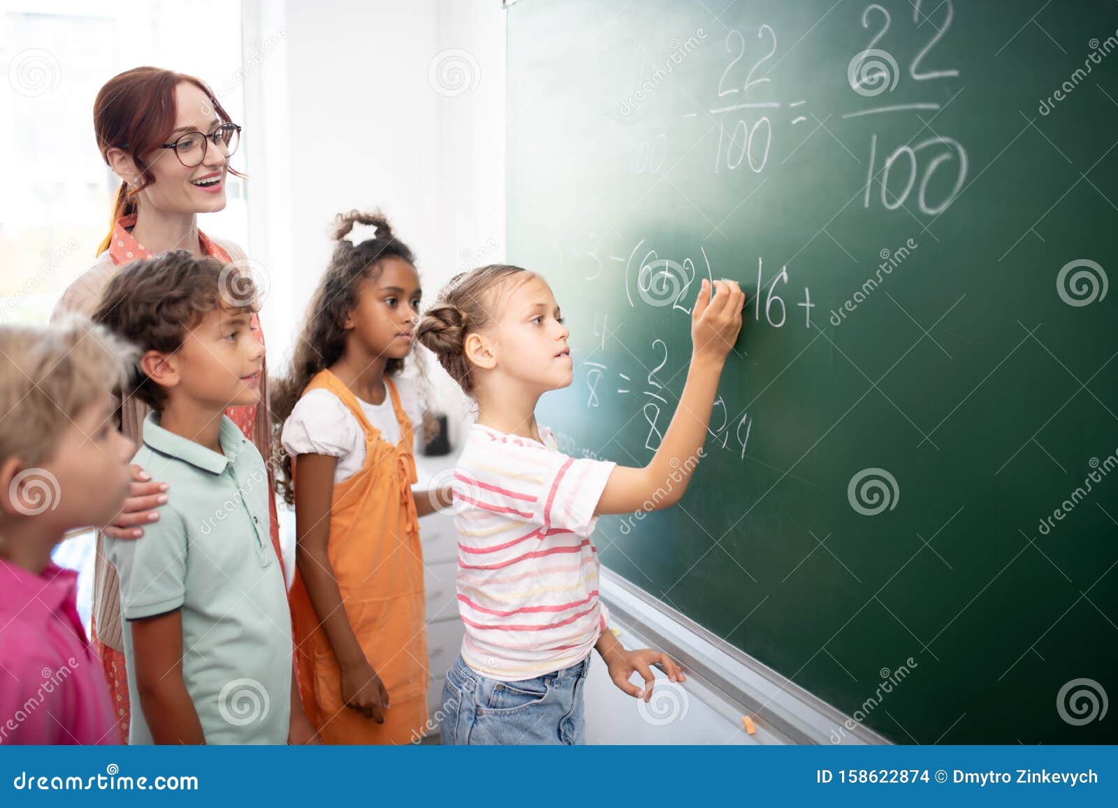Smart Girl Writing Down Numbers on Blackboard during Math Class Stock ...