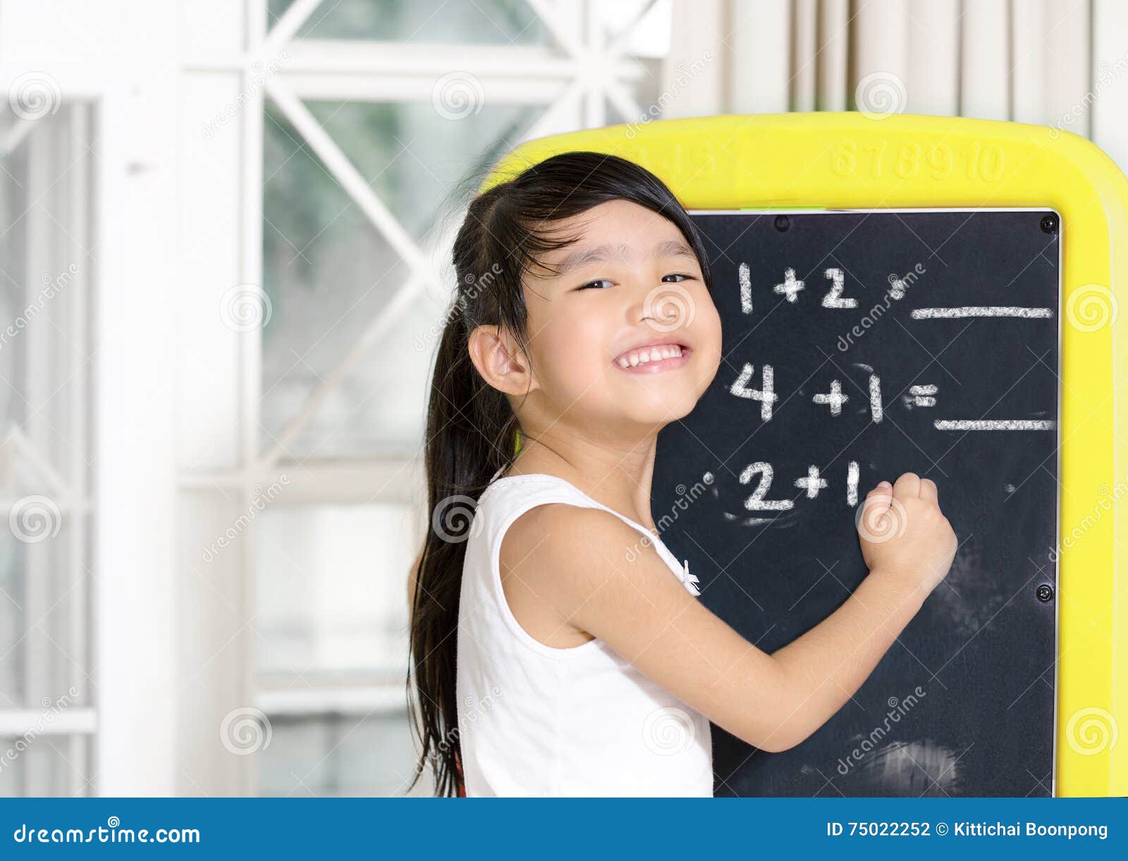 Smart Little Girl Smiling in Front of a Blackboard. Stock Photo - Image ...