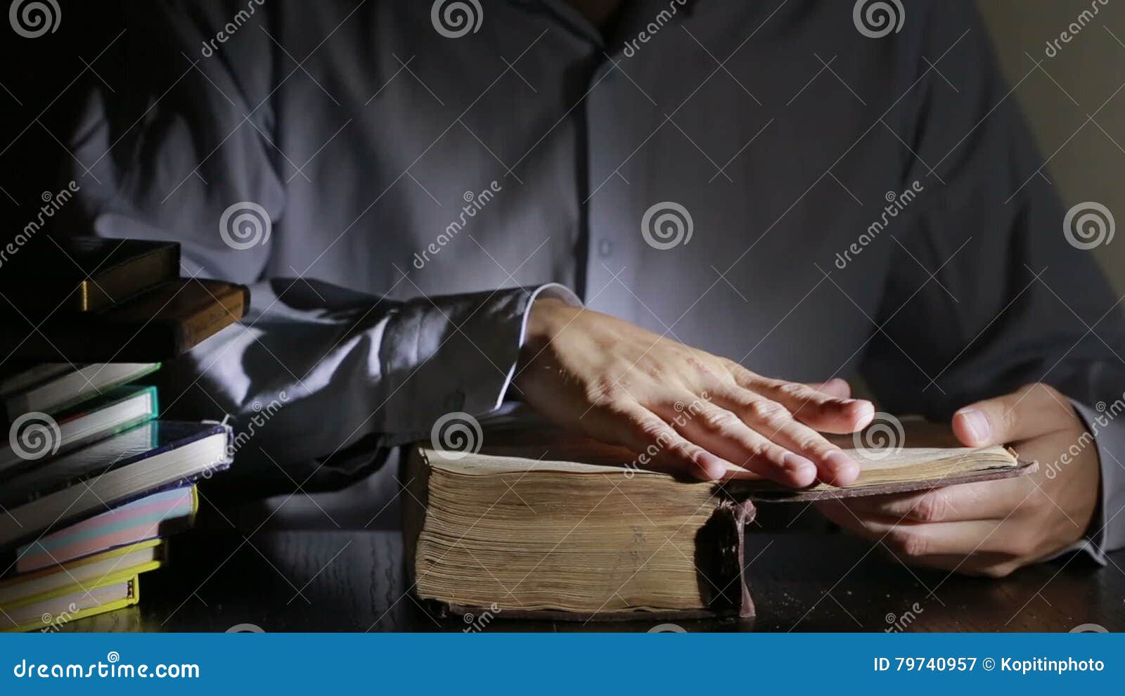 Smart Man Studying Late at Night, he is Sitting at Desk and Reading ...