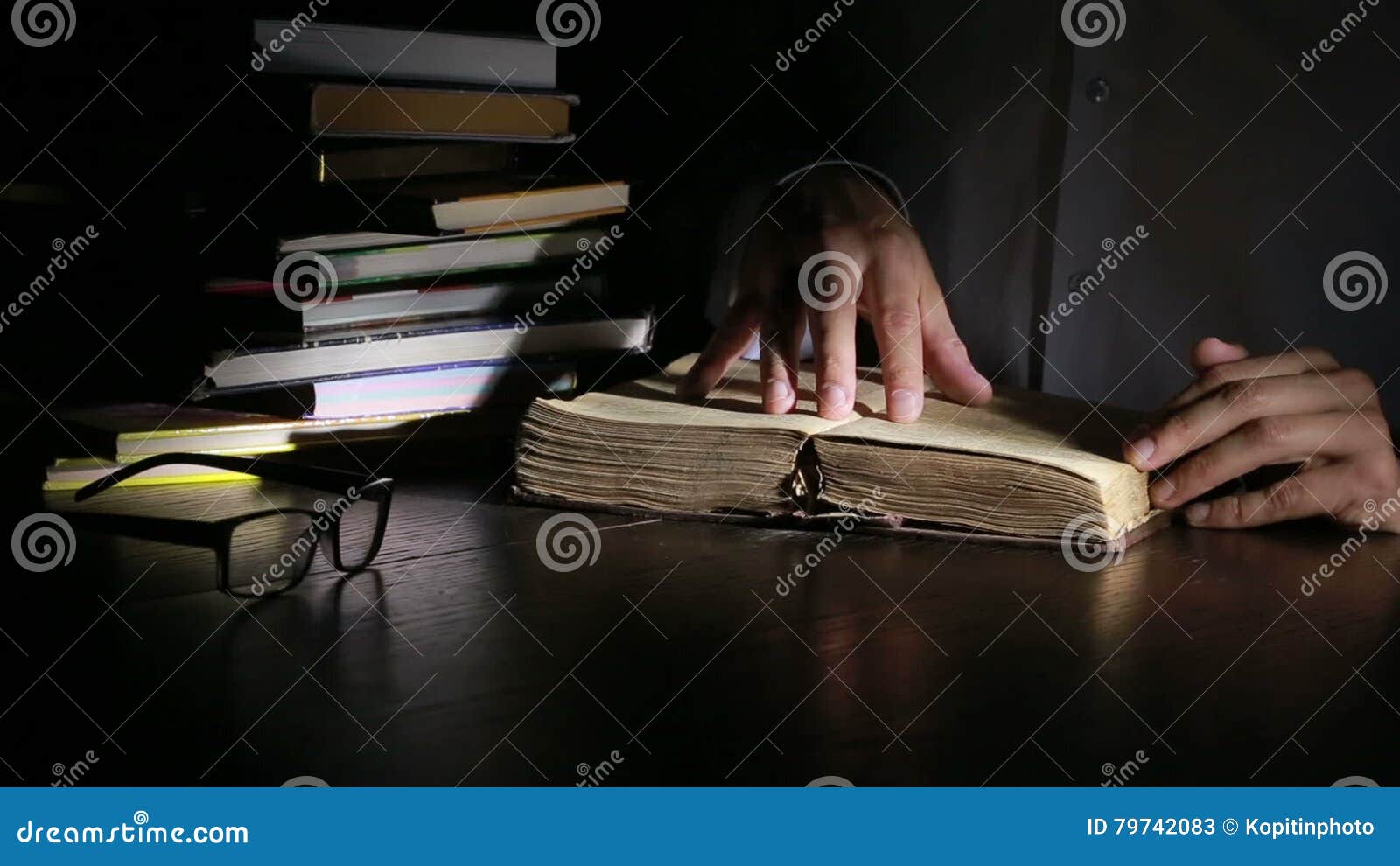 Smart Man Studying Late at Night, he is Sitting at Desk and Reading ...