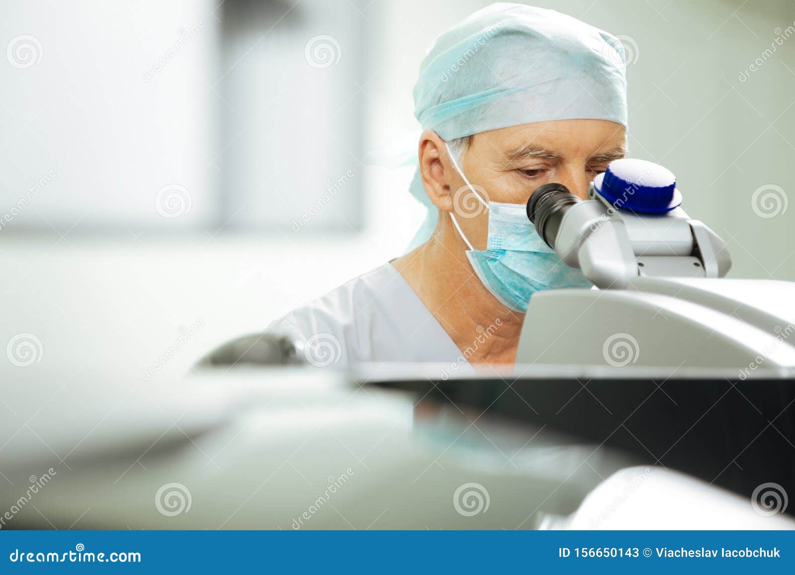 Smart Mature Doctor Sitting in Front of the Microscope Stock Image ...