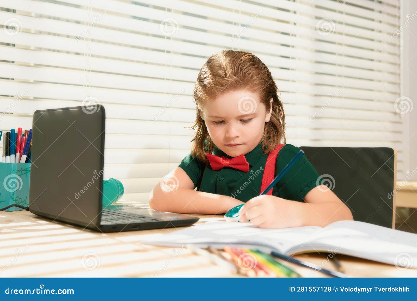 Smart School Boy Does Homework in School Class. Writes Text from Laptop ...