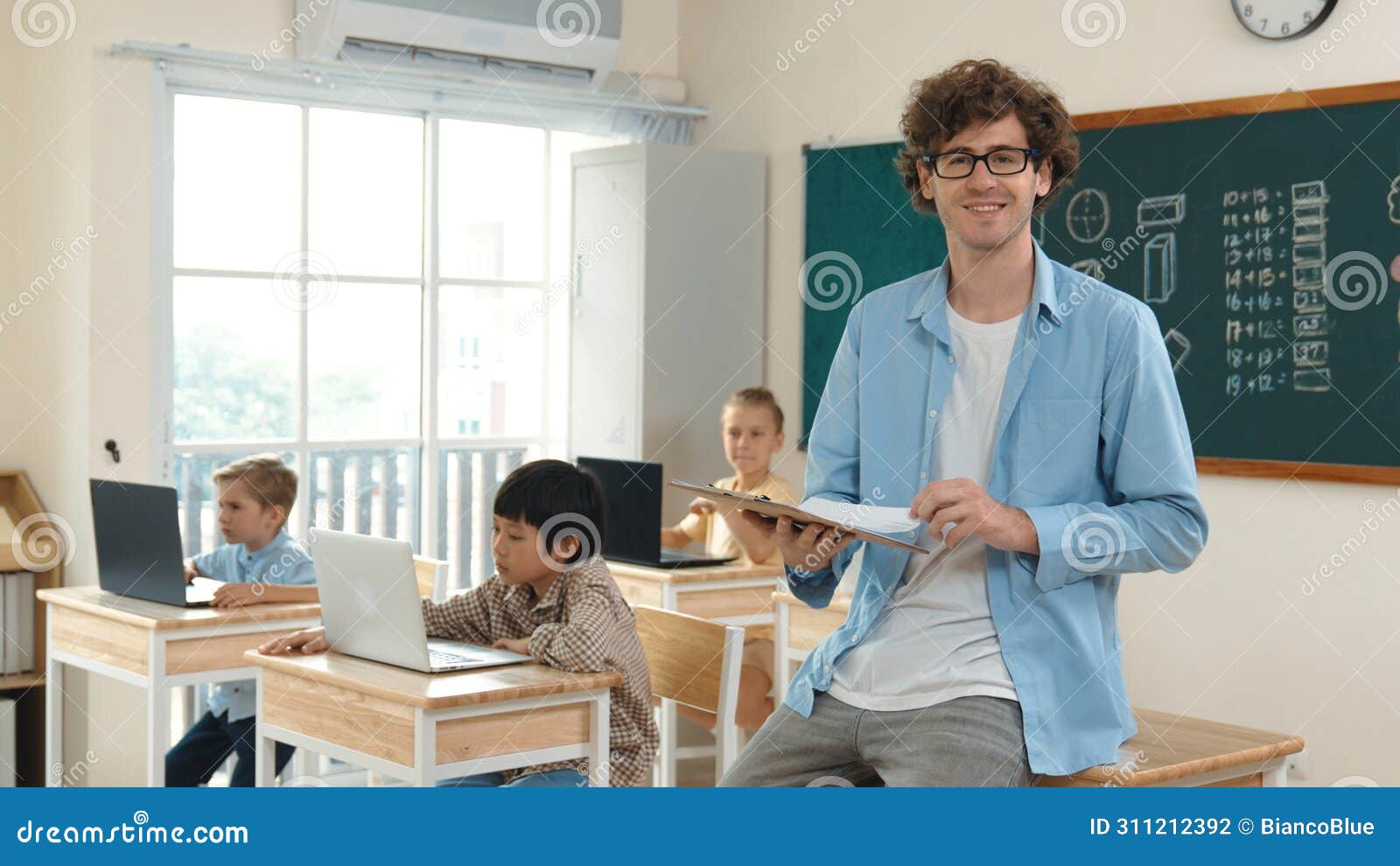 Smart Teacher Checking Document and Looking at Camera at Classroom ...