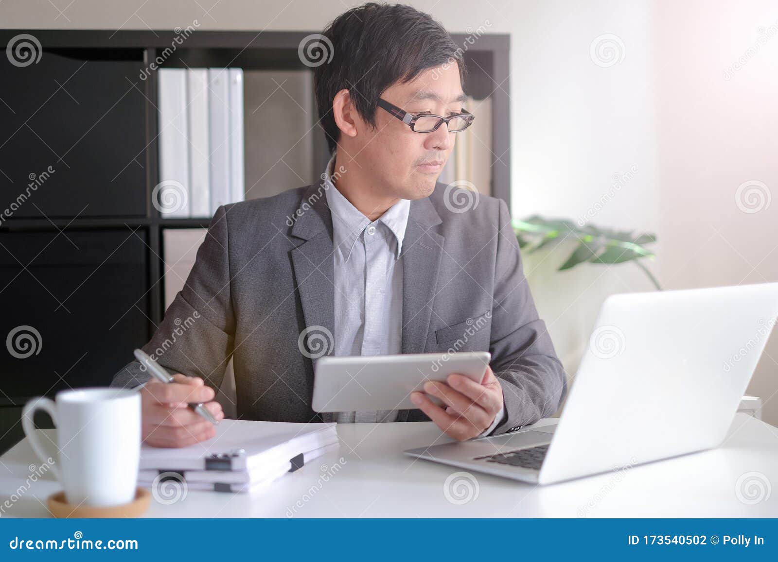 Smart Youngadult 40s Asian Man With Eye Glasses Working On Laptop Or