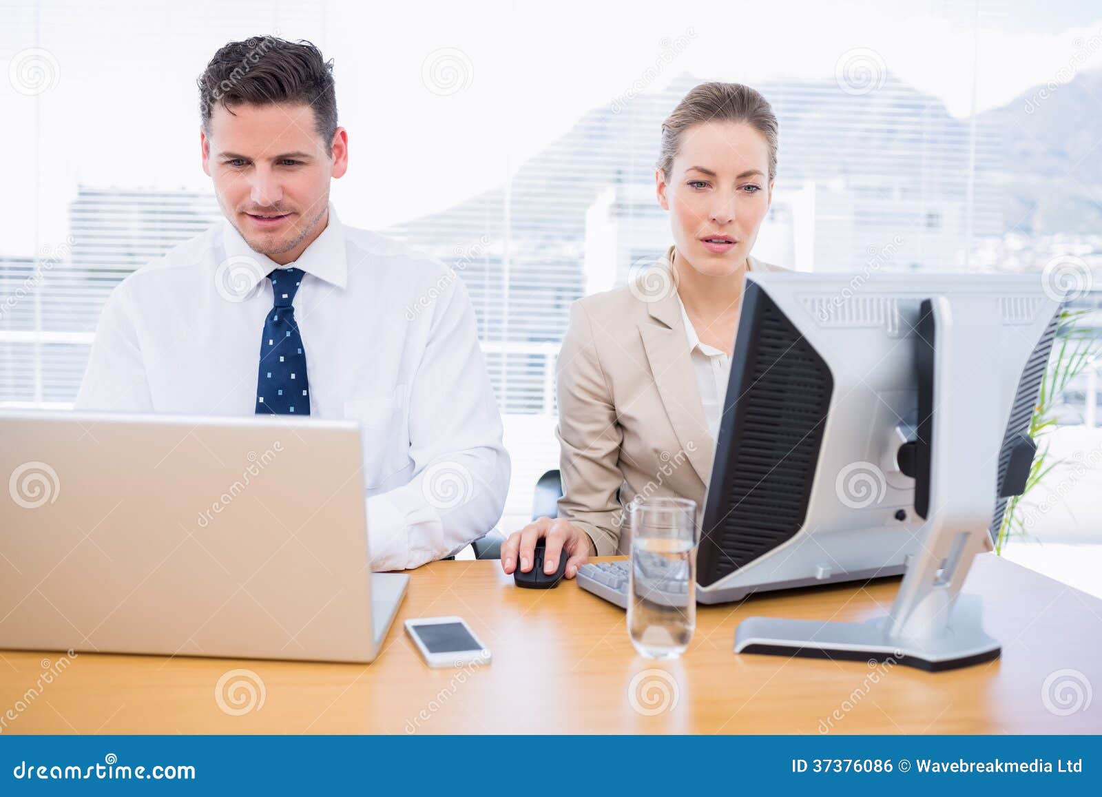 Smartly Dressed Colleagues Using Computer and Laptop Stock Photo ...