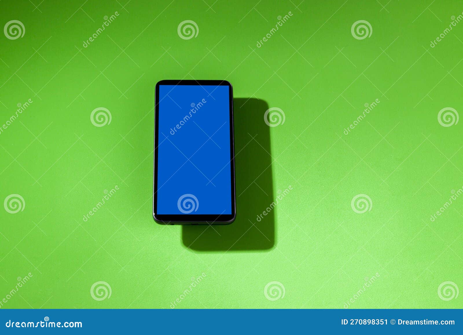 Smartphone with a Blue Screen on Top of a Green Table. Stock Image ...