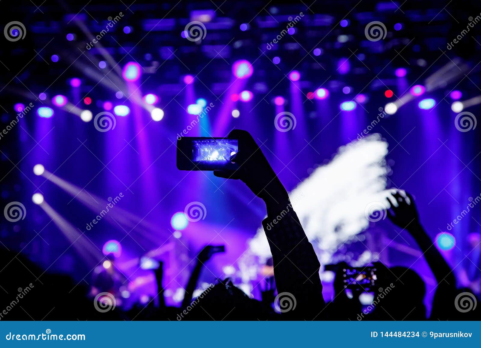 Smartphone in Hand at a Concert, Blue Light from Stage Stock Photo ...