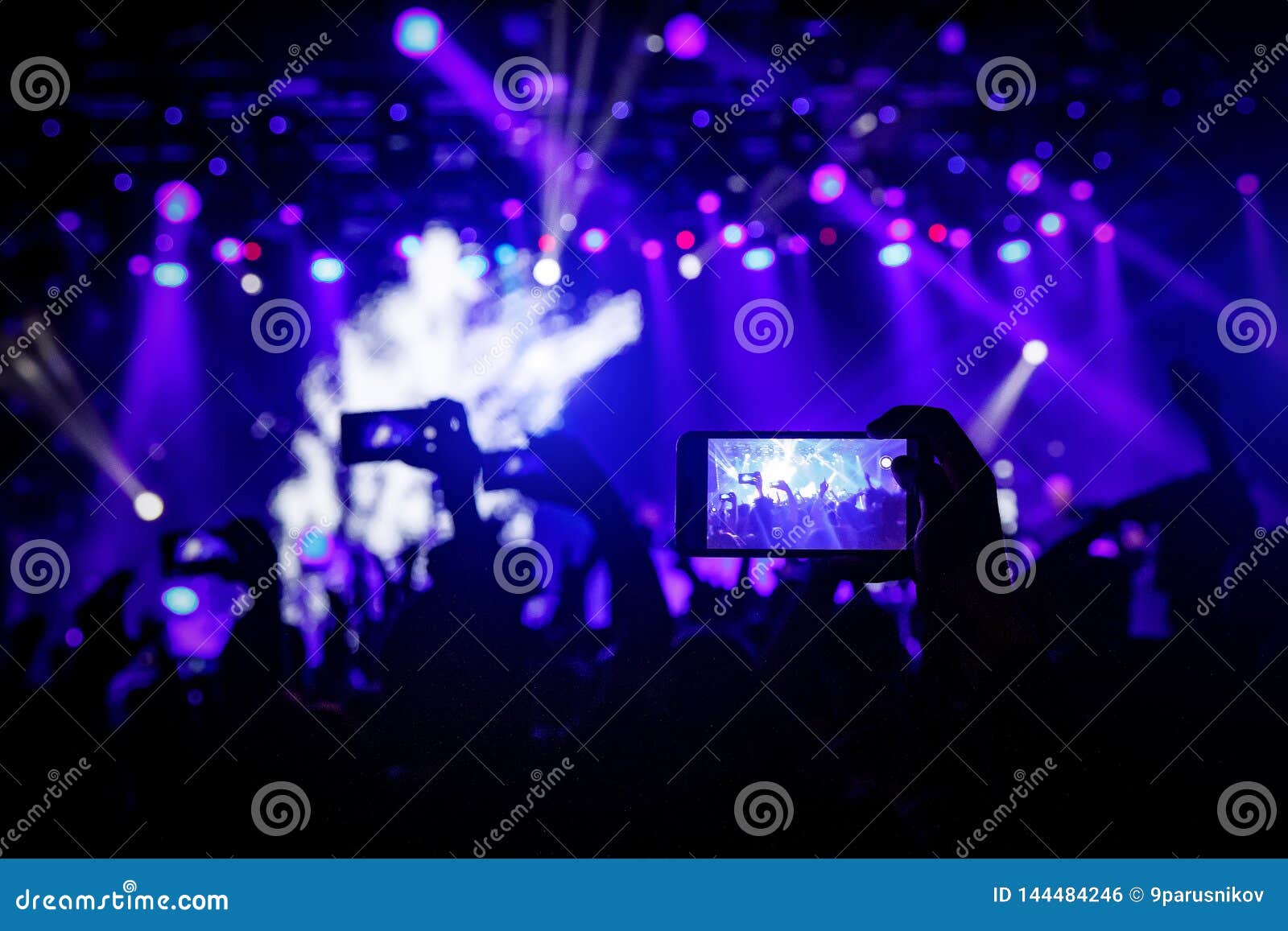 Smartphone in Hand at a Concert, Blue Light from Stage Stock Photo ...