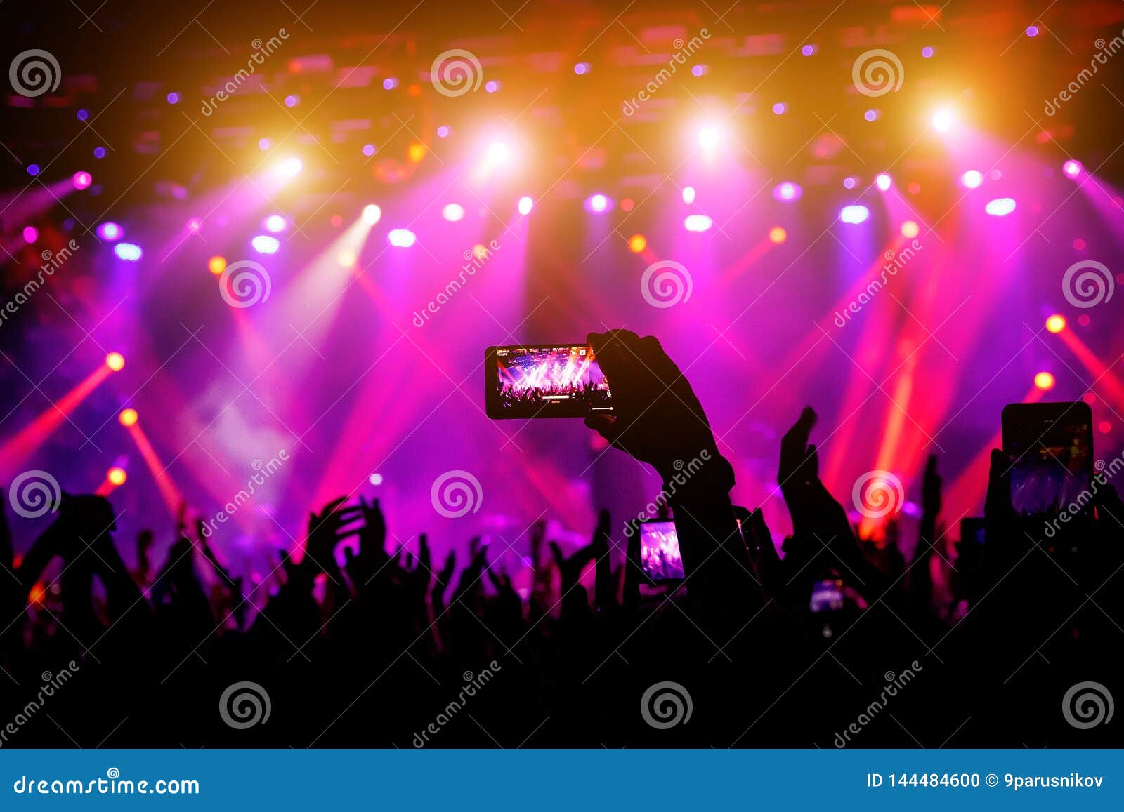 Smartphone in Hand at a Concert, Purple Light from Stage Stock Photo ...