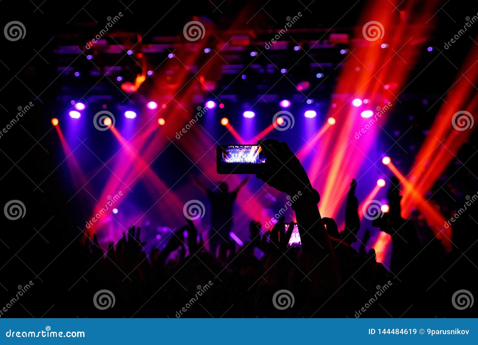Smartphone in Hand at a Concert, Purple Light from Stage Stock Image ...
