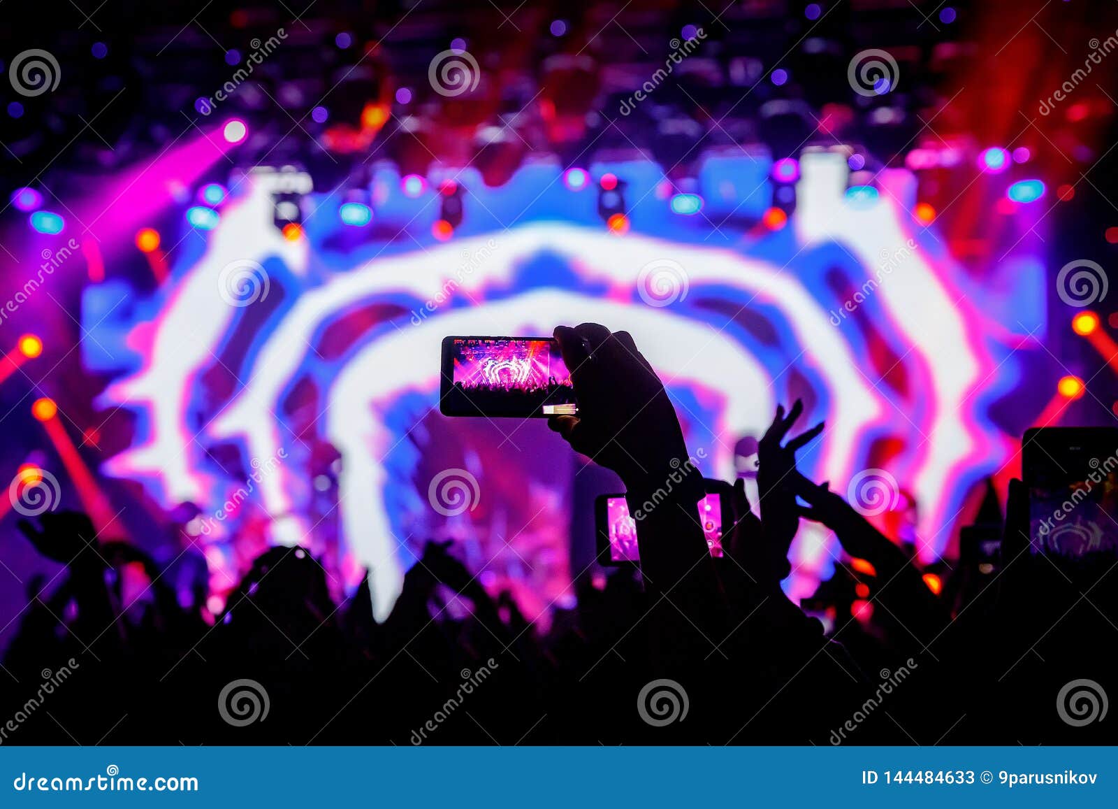 Smartphone in Hand at a Concert, Purple Light from Stage Stock Image ...