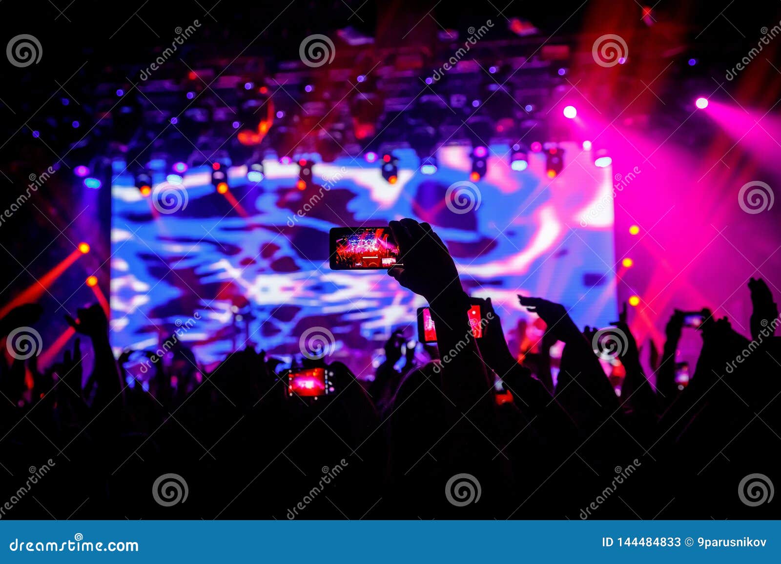 Smartphone in Hand at a Concert, Purple Light from Stage Stock Image ...