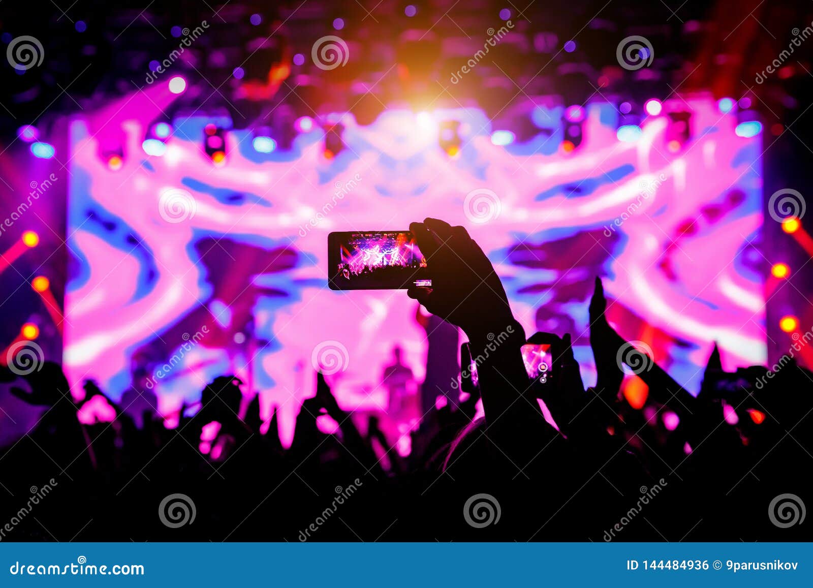 Smartphone in Hand at a Concert, Purple Light from Stage Stock Photo ...