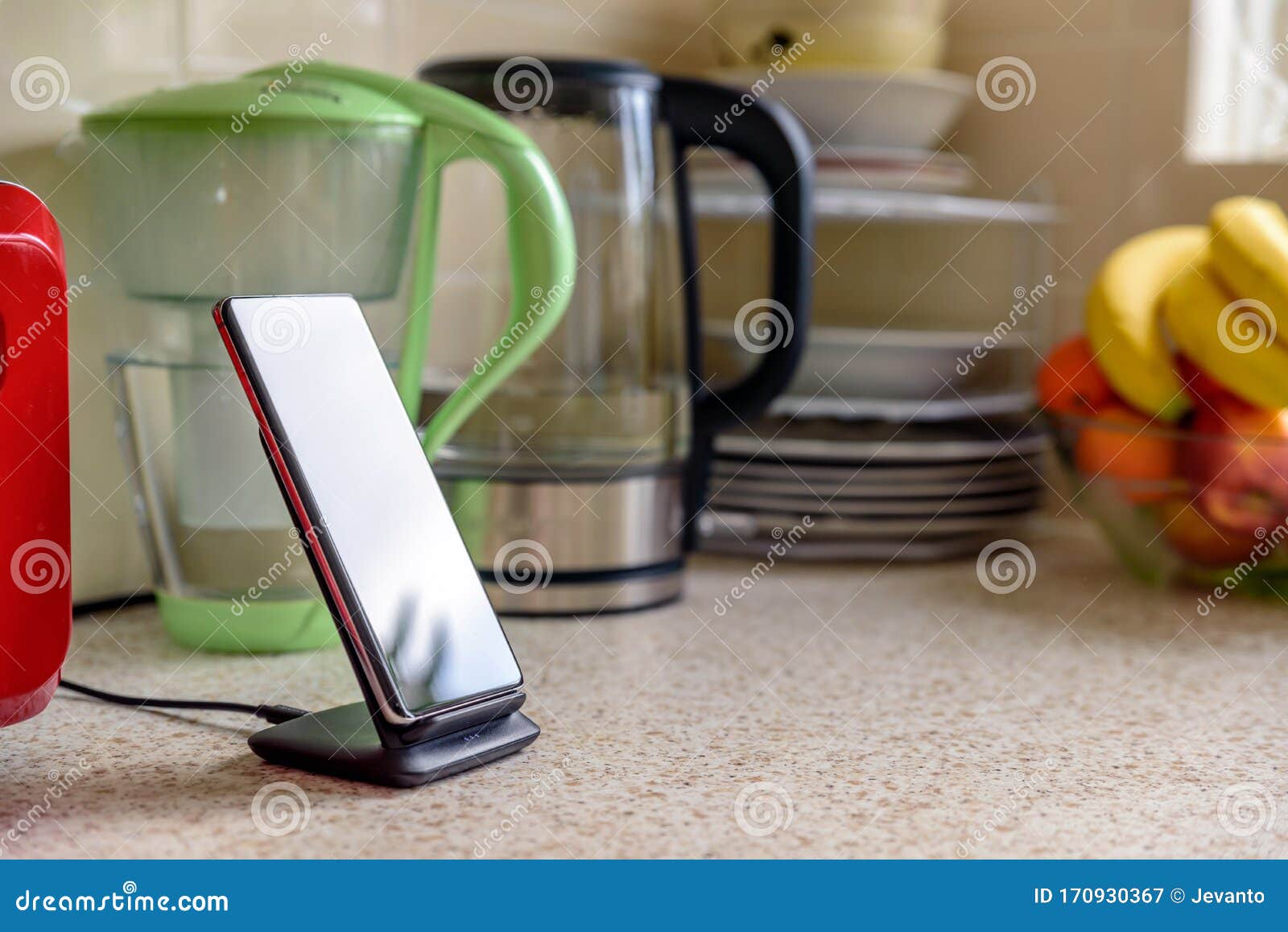 Smartphone Wireless Charging on Charging Stand on Kitchen Tabletop ...