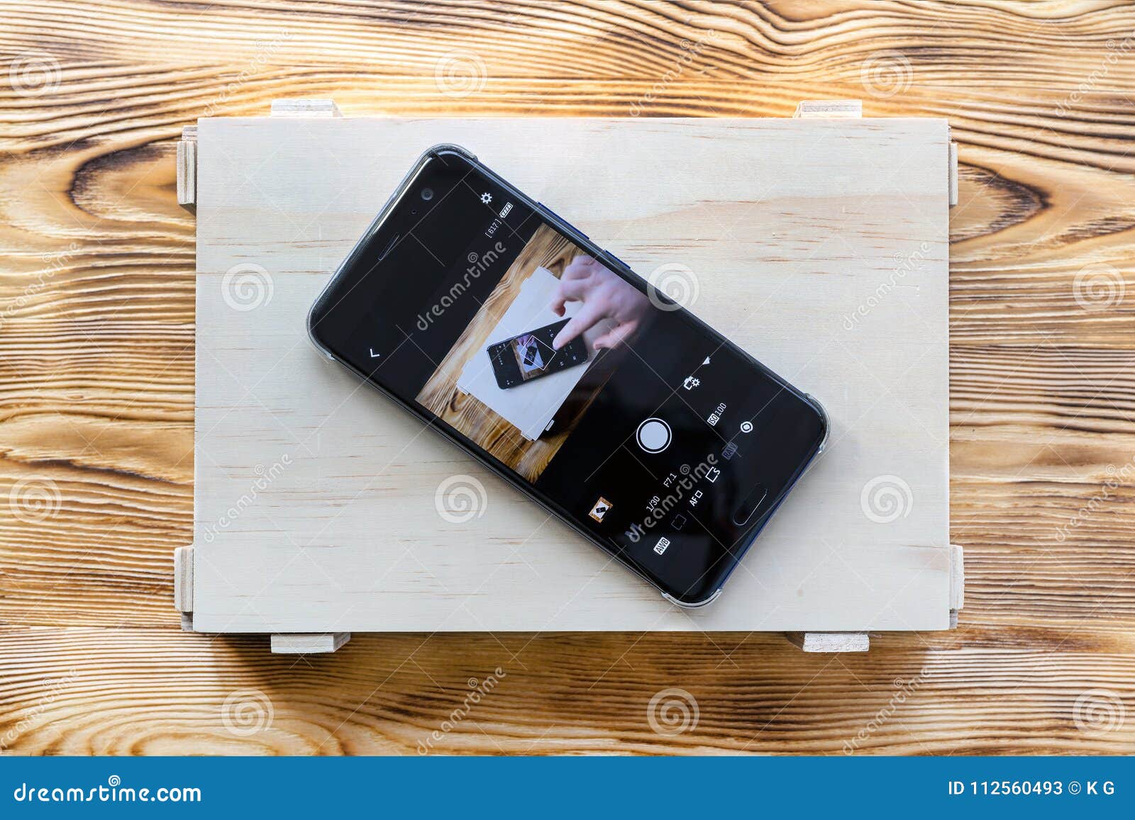 Smartphone on a Wooden Box with Itself Image on Screen. Remote Camera ...