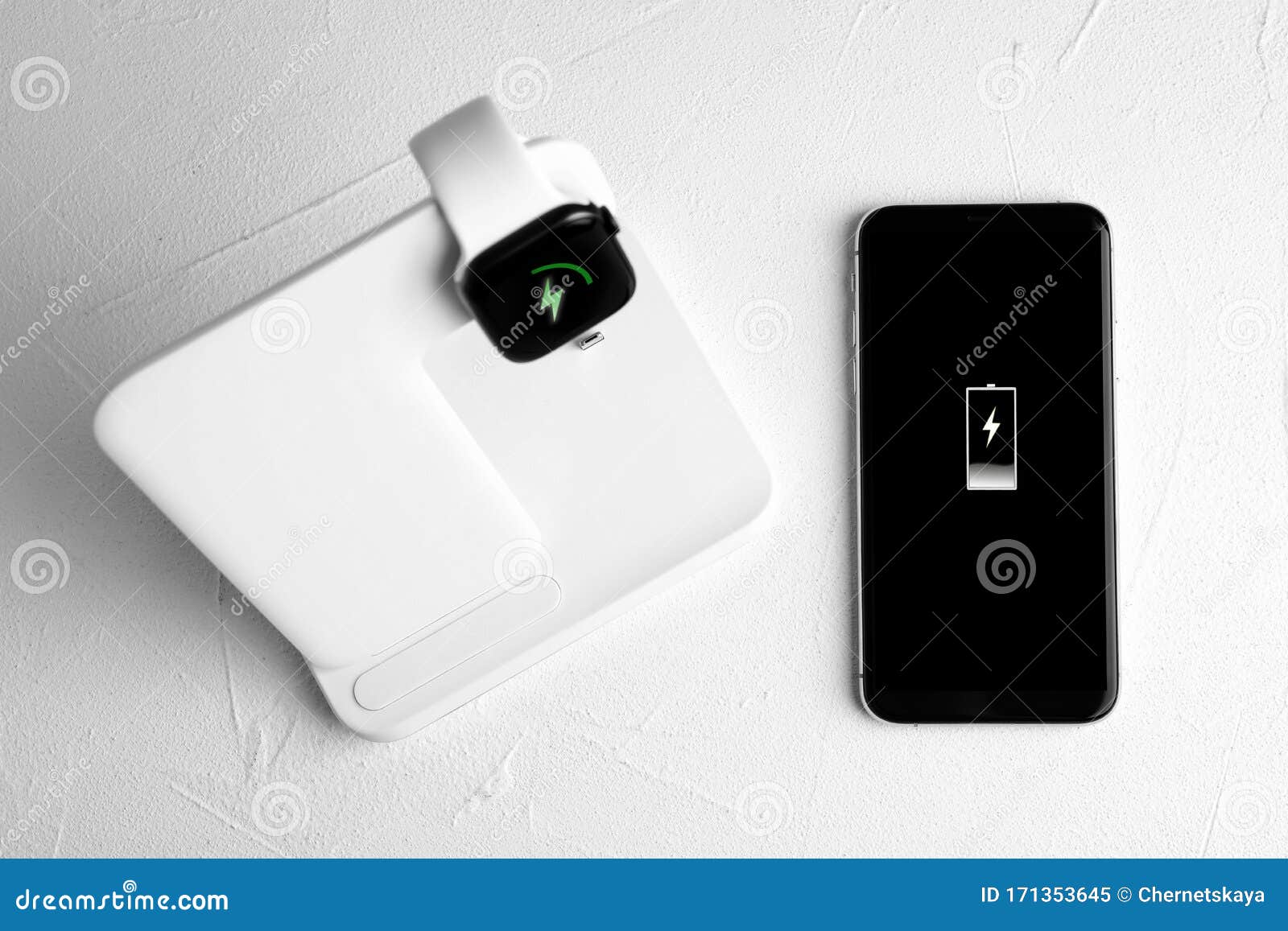 Smartwatch Charging with Wireless Pad and Phone on White Stone Table ...