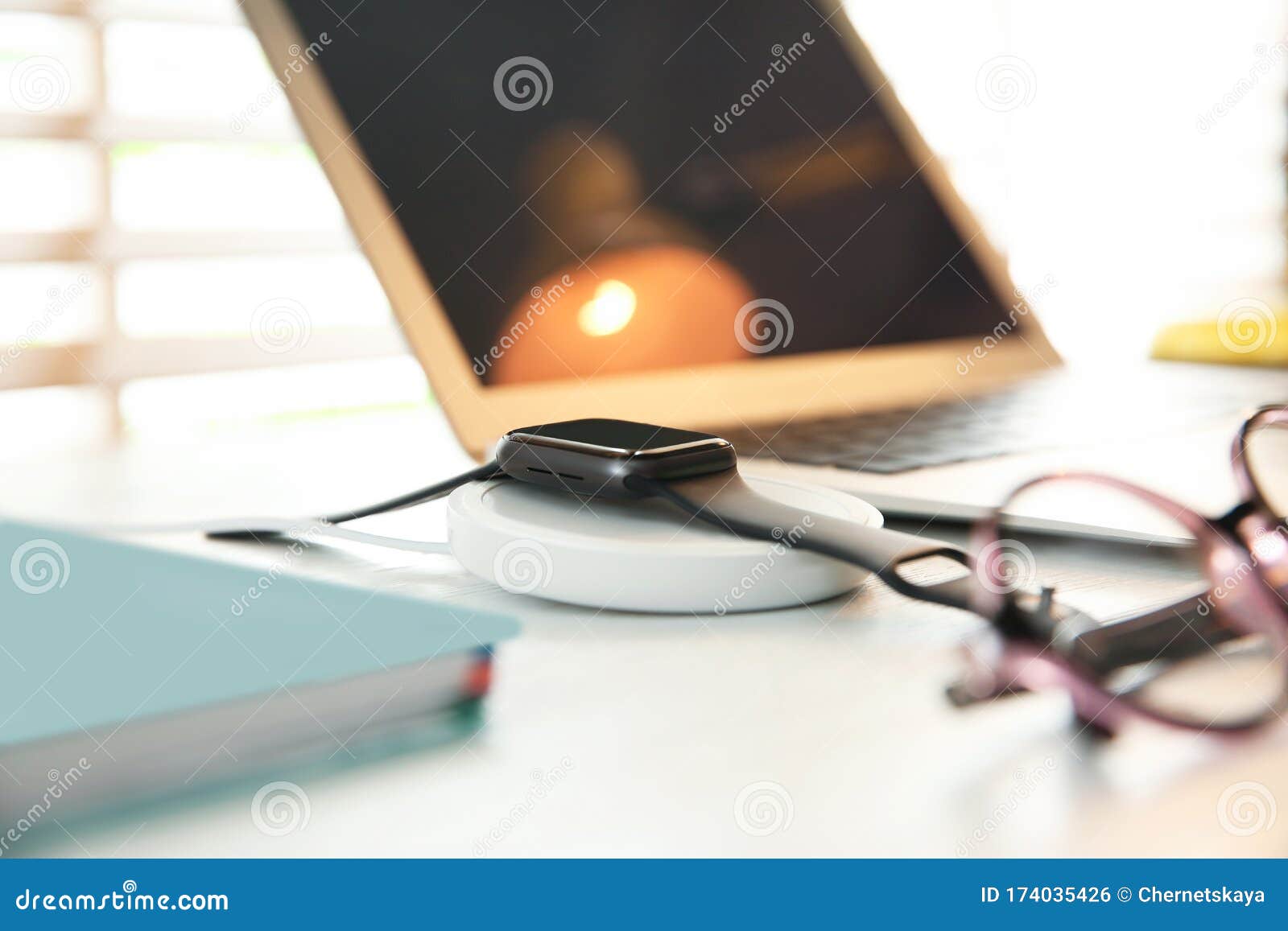 Smartwatch with Wireless Charger on White Wooden Table. Modern ...