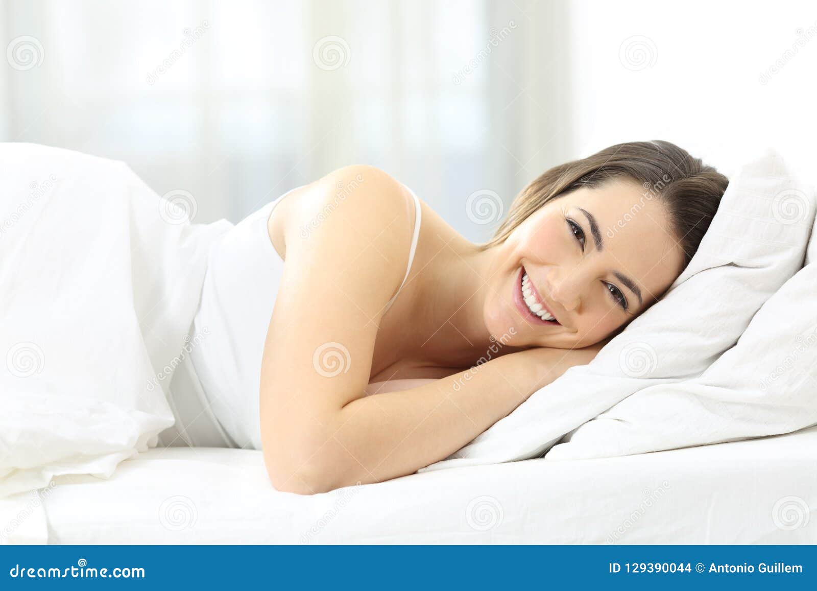 Smiley Woman Lying on the Bed Looking at You Stock Photo - Image of ...