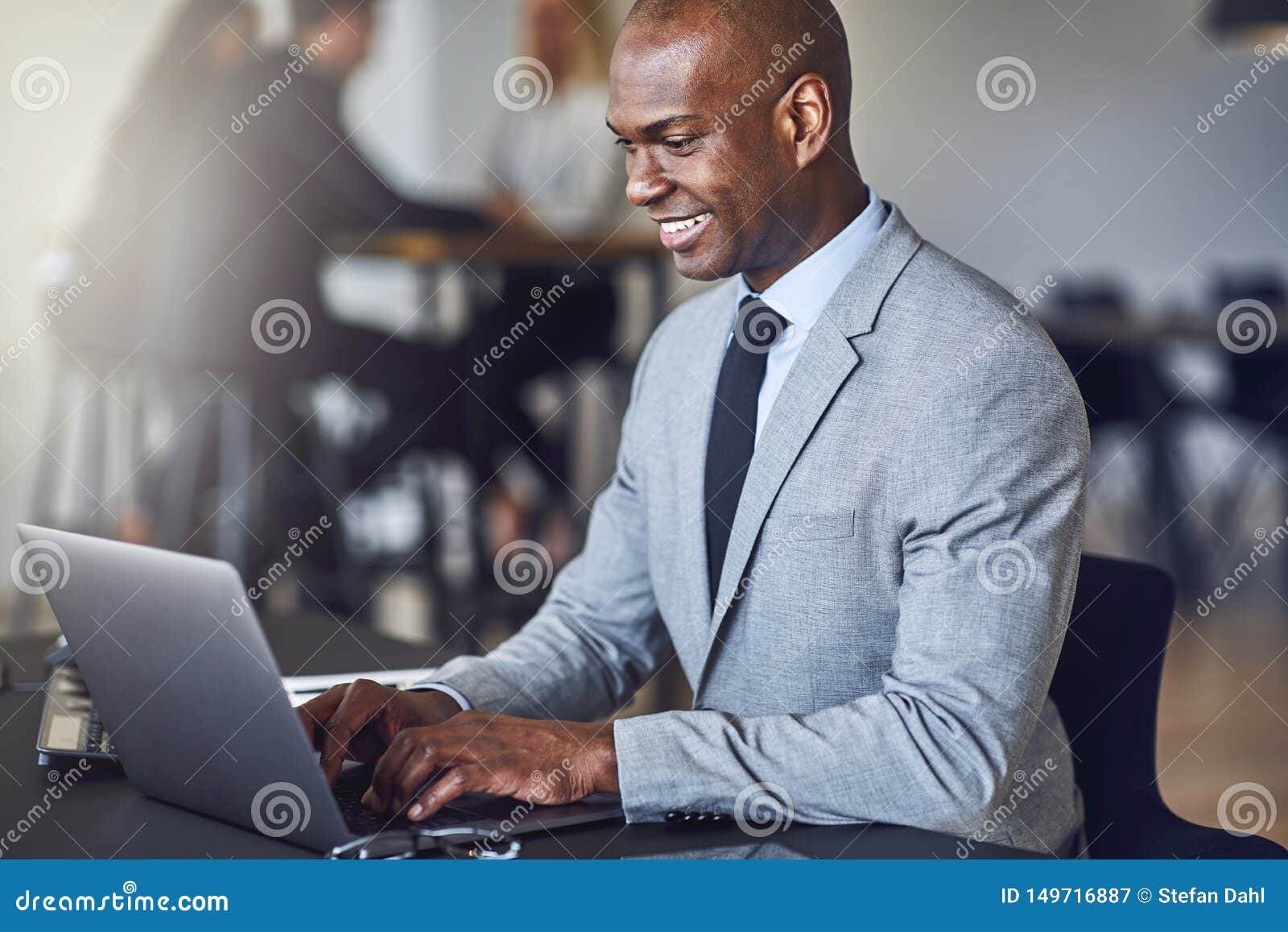 Smiling African American Businessman Working Online in a Modern Stock ... Smiling African American Businessman Working Online in a Modern Stock ...