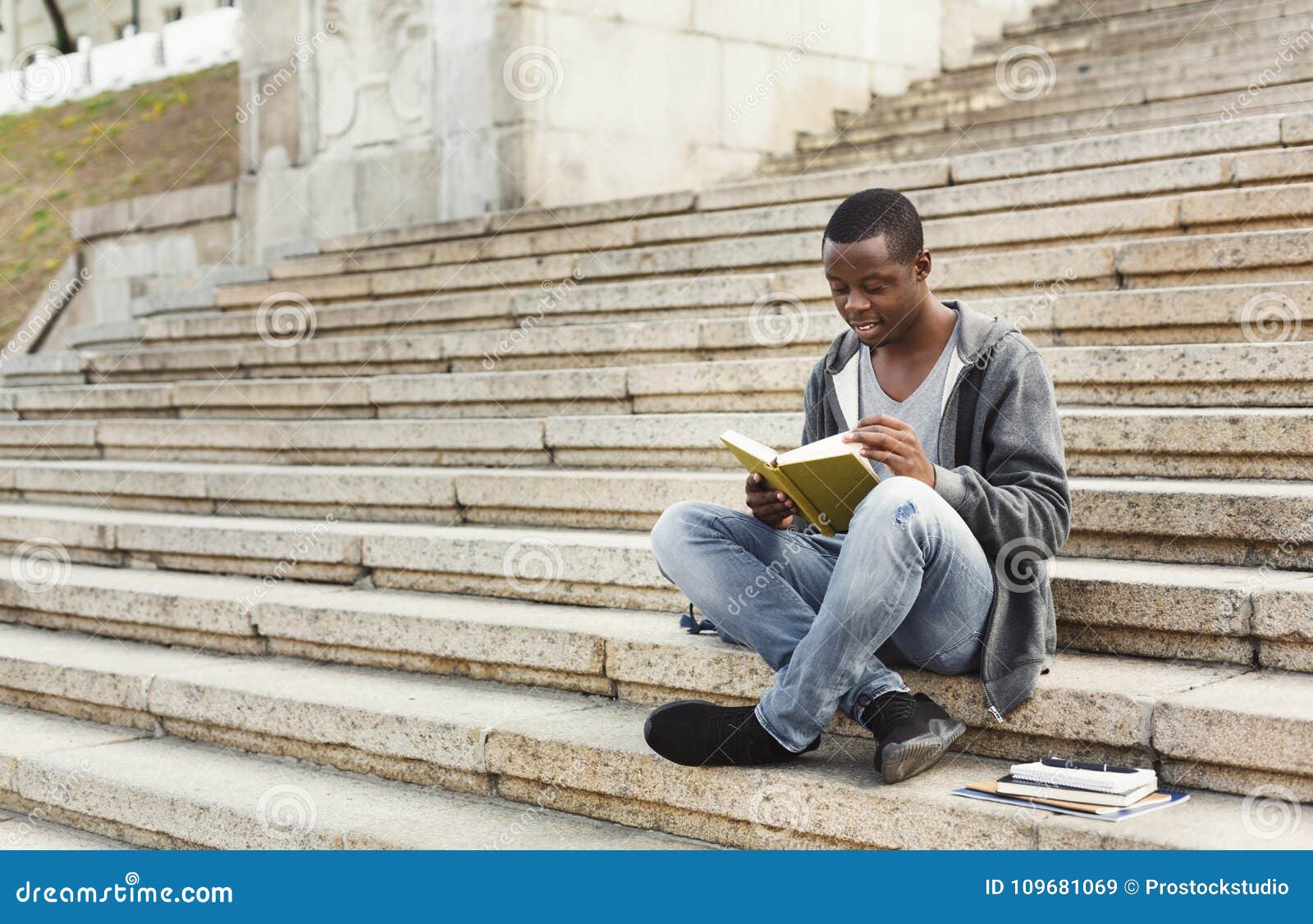 Smiling African-american Student Reading Book on University Stairs ... Smiling African-american Student Reading Book on University Stairs ...