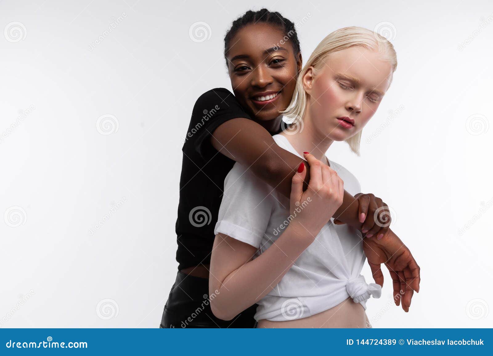 Smiling African American Woman Hugging Her White Skinned Friend Stock