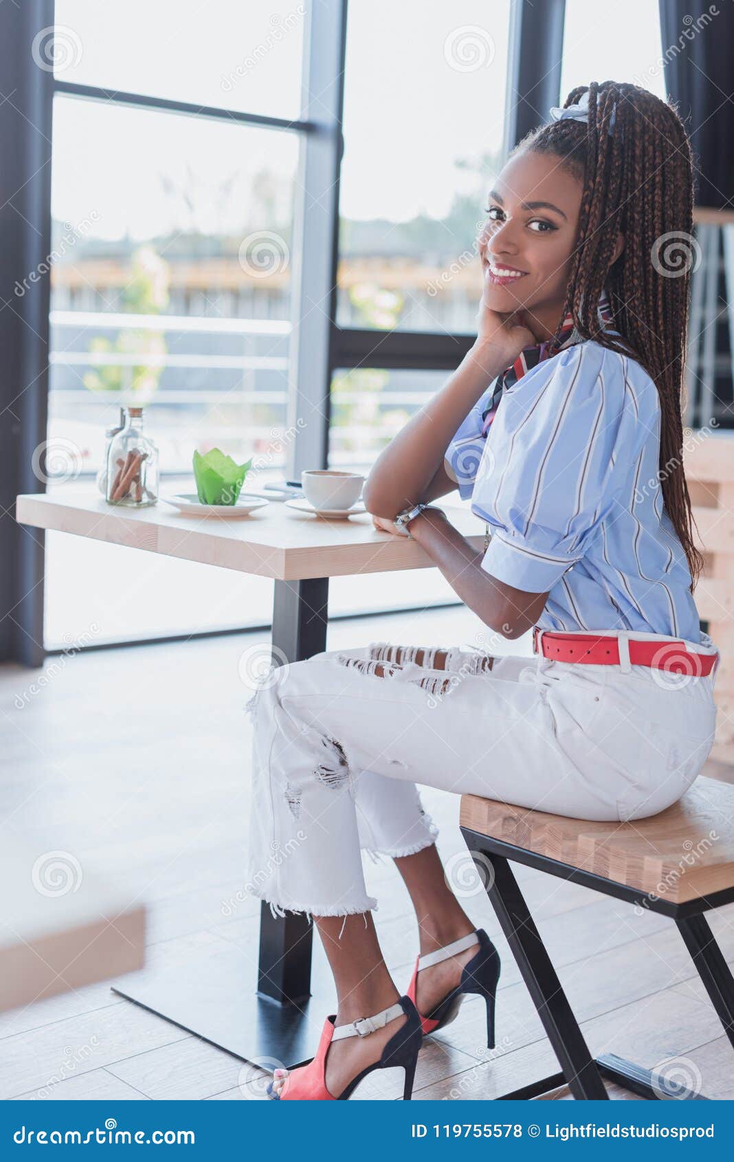 Smiling African American Woman Sitting At The Table In A Cozy Coffee