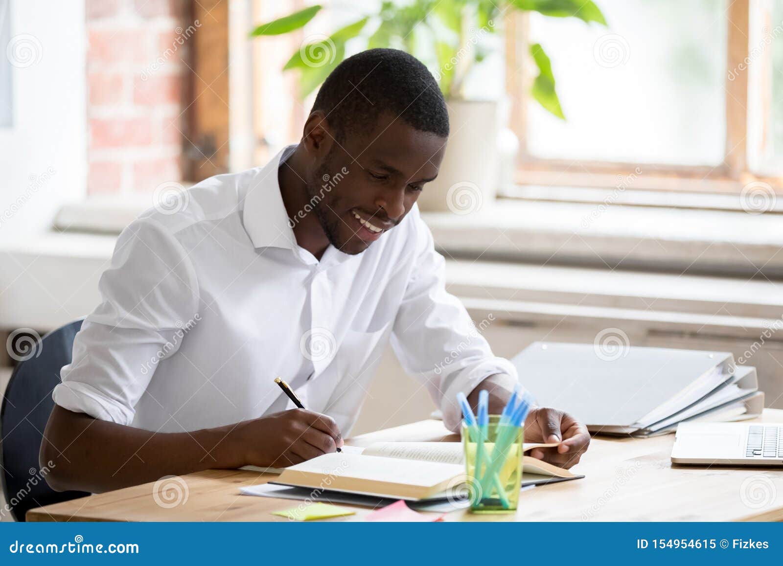 Smiling African Student Holding Pen Making Notes Preparing for Test ...