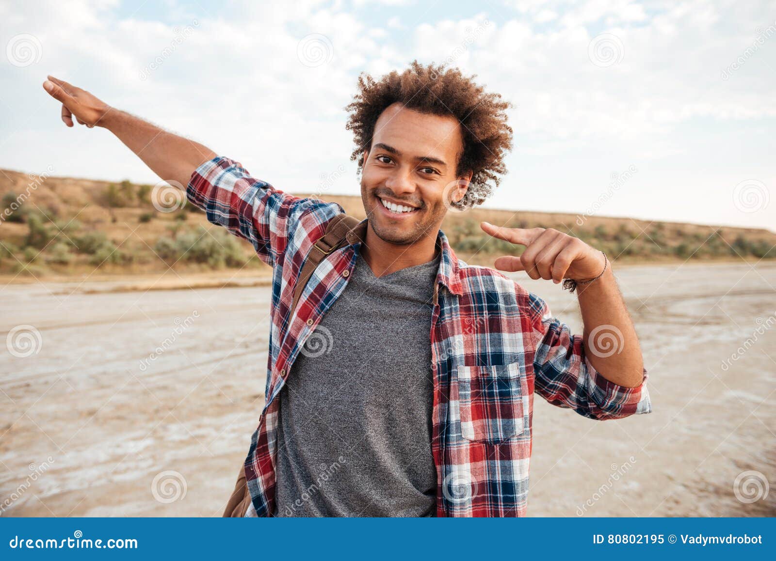Smiling African Young Man Pointing Away by Both Hands Outdoors Stock ...