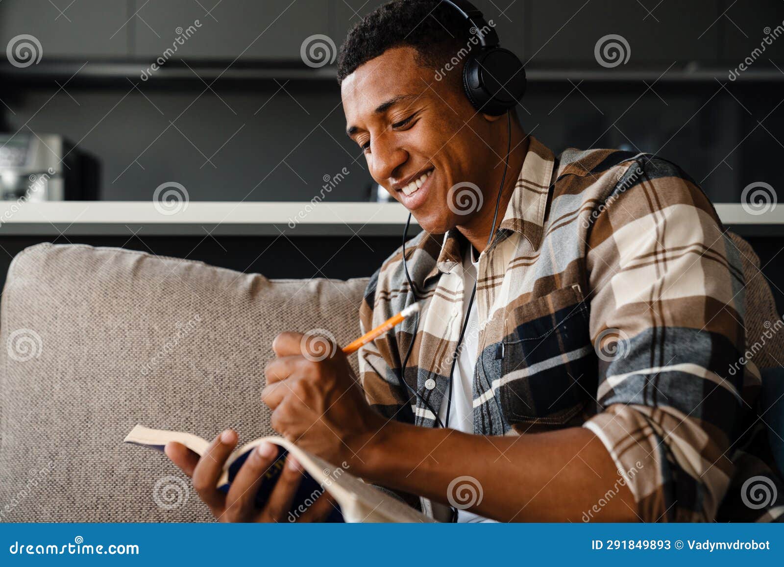 Smiling Afro Man Writing Down Notes while Sitting on Sofa Stock Image ...