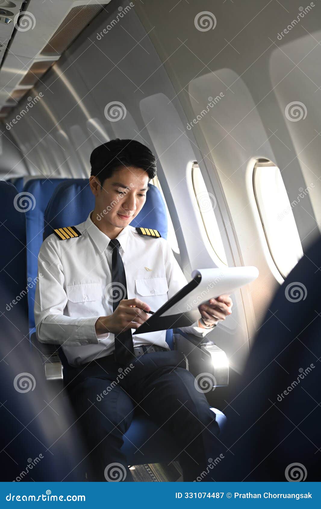 Smiling Asian Pilot with Clipboard Checking Flight Plan or Preparing ...