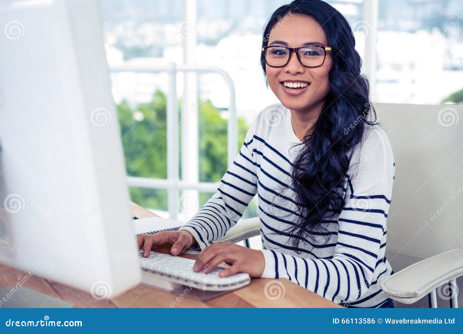 Smiling Asian Woman Using Computer and Looking at the Camera Stock ...