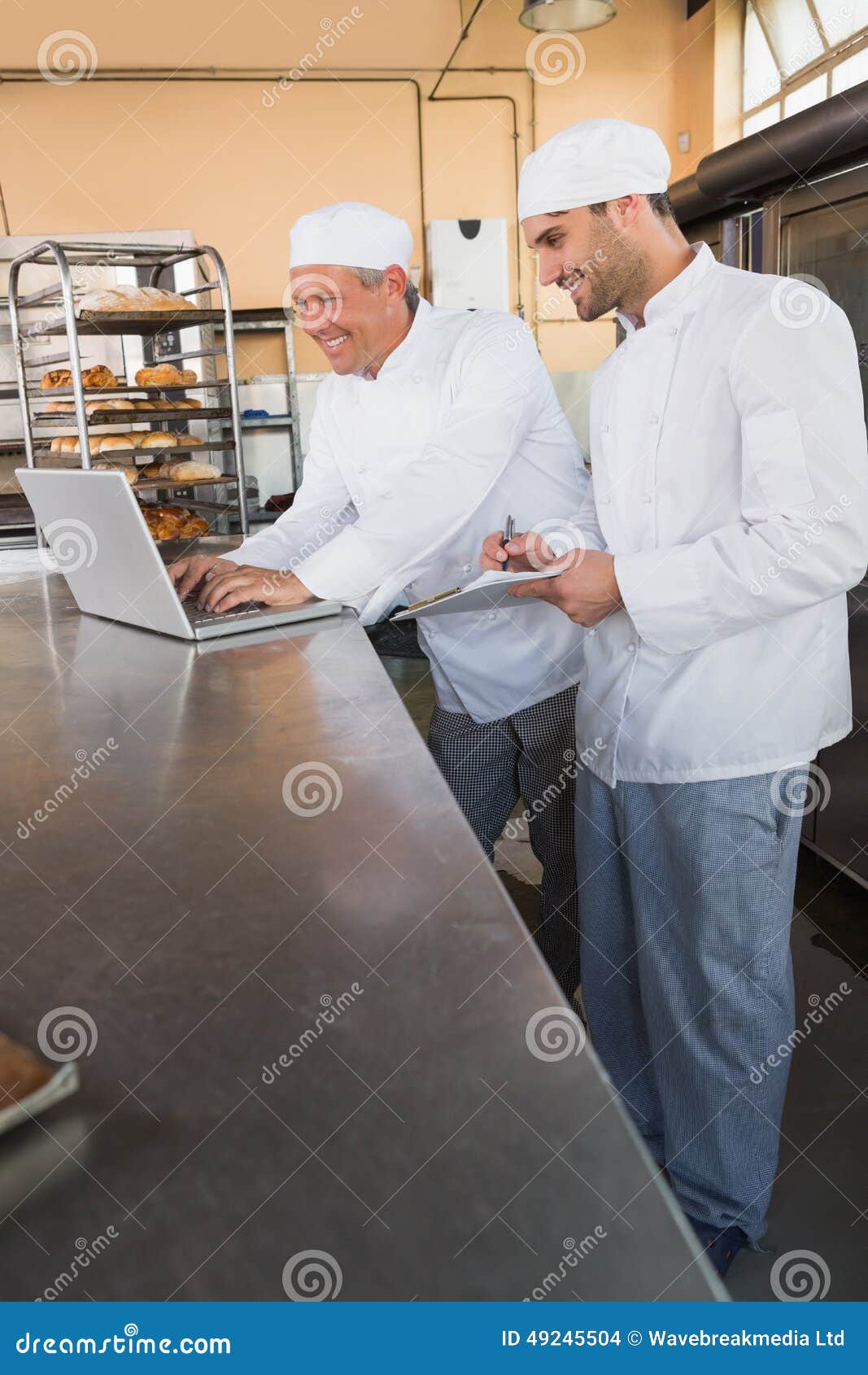 Smiling Bakers Working Together on Laptop Stock Photo - Image of bread ...