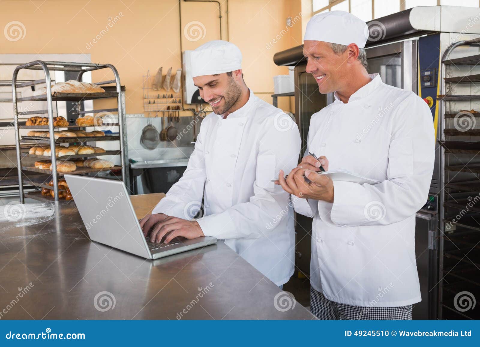 Smiling Bakers Working Together on Laptop Stock Photo - Image of bakery ...