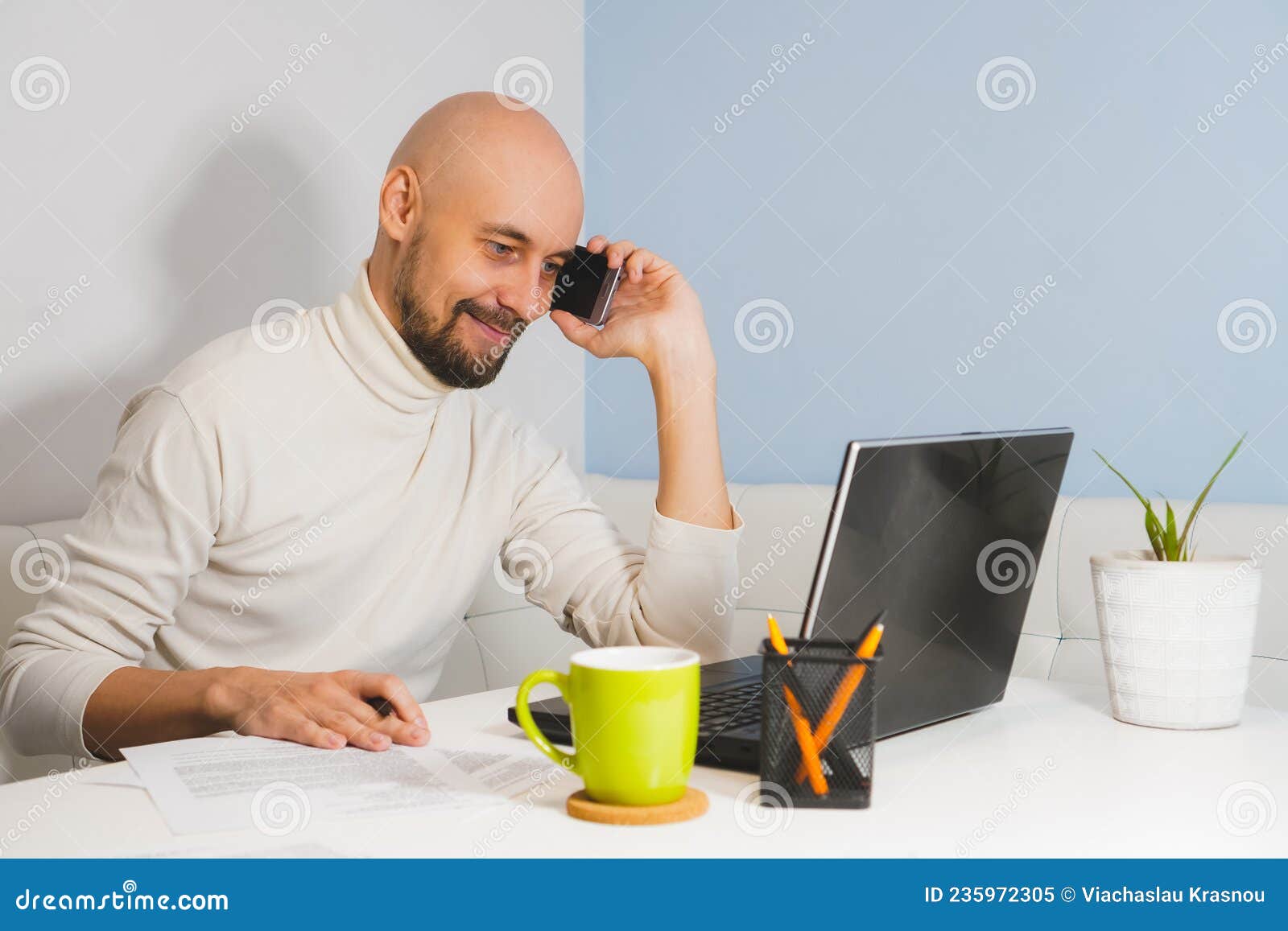 Smiling Bald Man with Beard in White Turtleneck Working at Home on ...